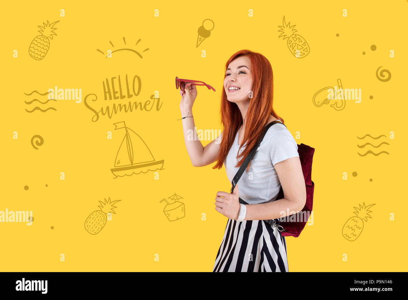 Positive person wearing a little backpack and smiling while enjoying ...