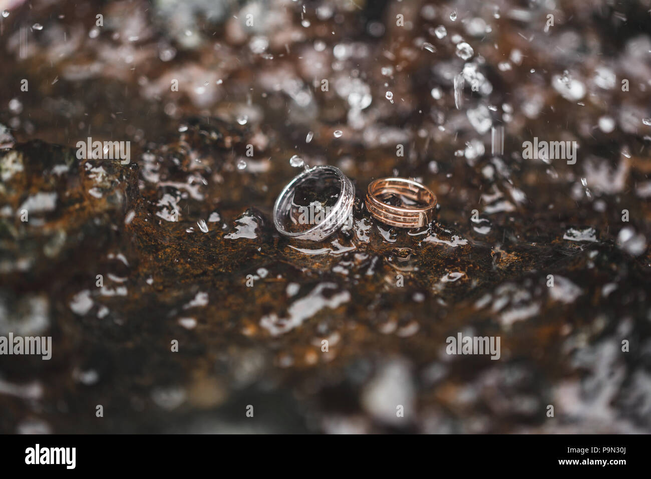 Wedding rings on water surface texture Stock Photo - Alamy