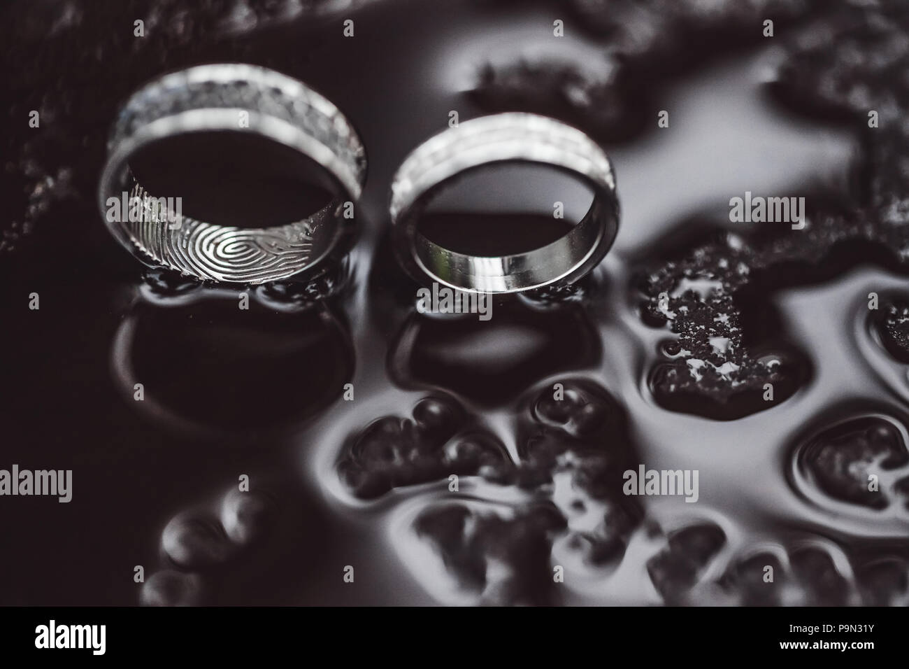 Wedding rings on water surface texture Stock Photo - Alamy