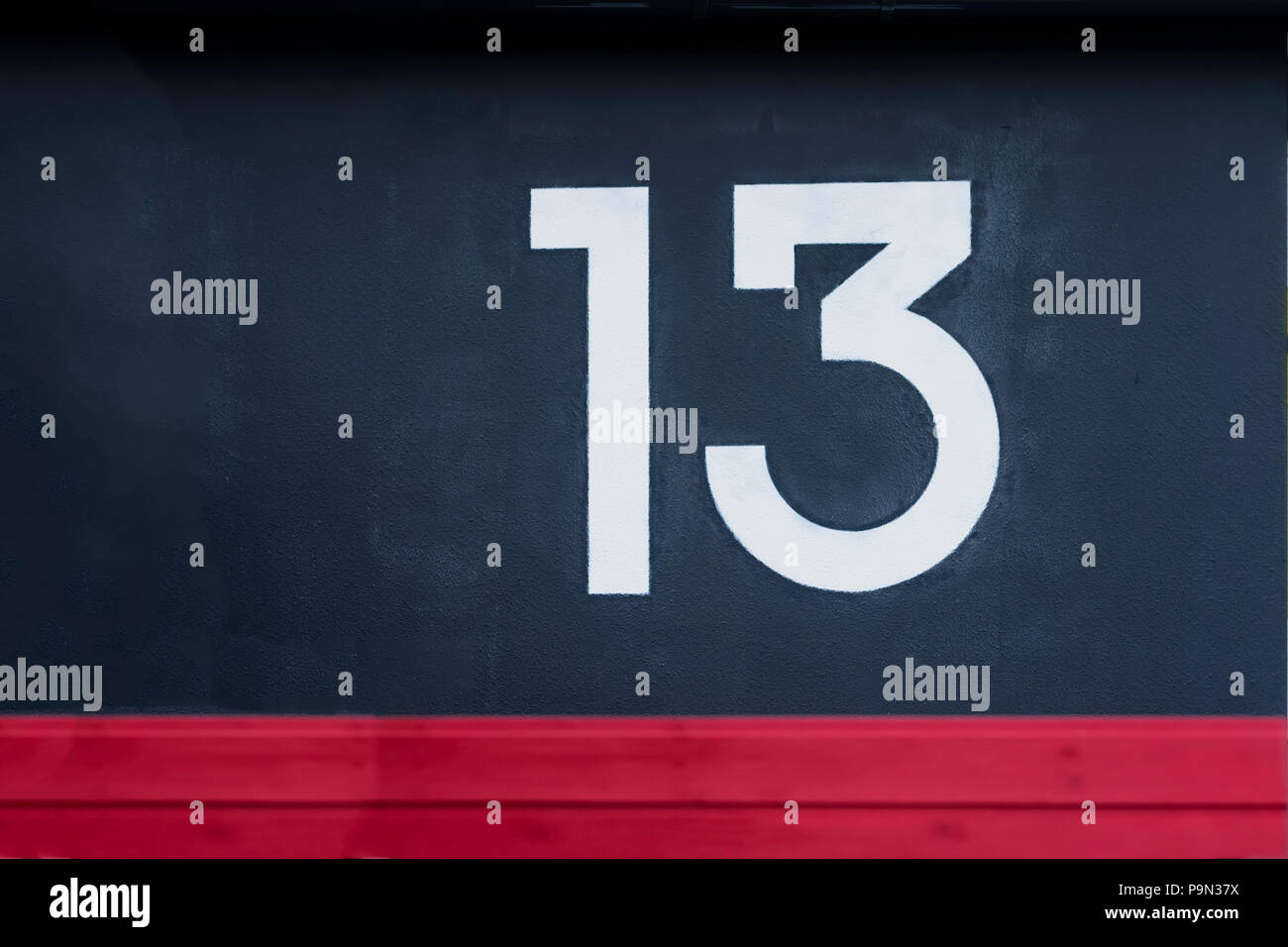 Written number thirteen on the blue red concrete wall Stock Photo - Alamy