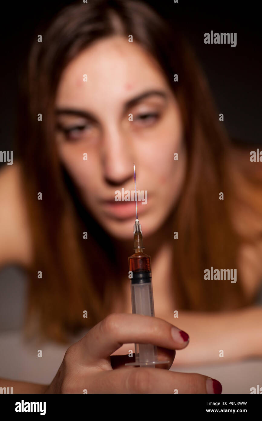 A girl with syringe and dark circles around her eyes. Drugs addiction ...