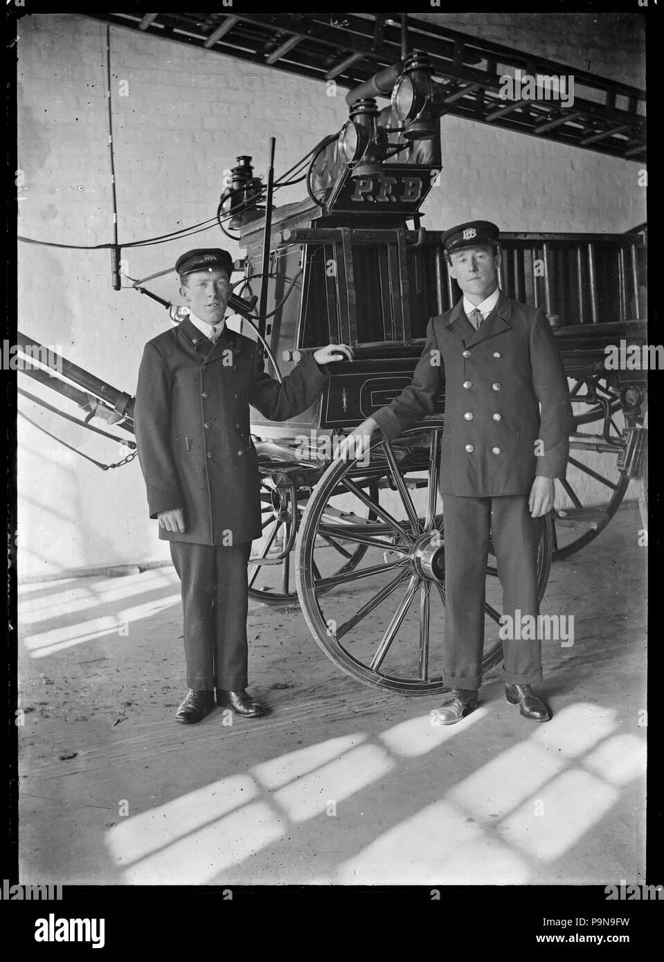 318 Two firemen standing beside the engine at the Petone Fire Station ...
