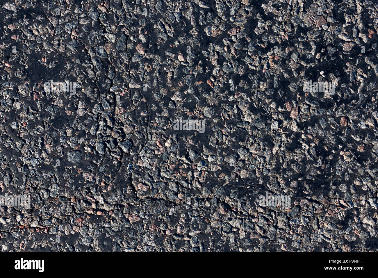 a piece of asphalt road made of rubble, asphalt and black resin, close ...
