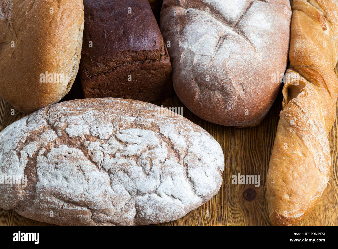 different kinds of bread lying together on a wooden table, photo in a ...
