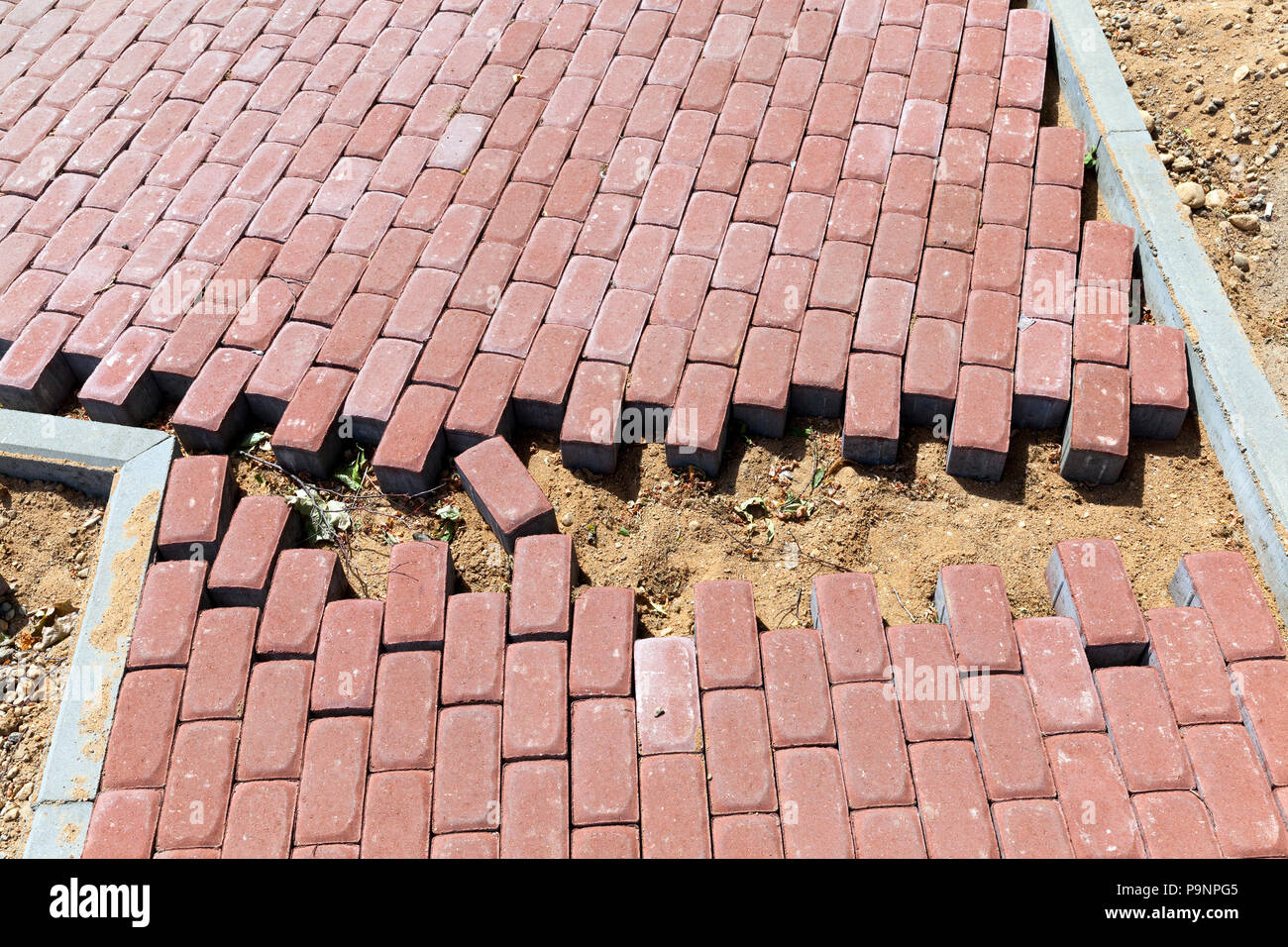 the construction of a new pedestrian road in a park of red tiles, a ...