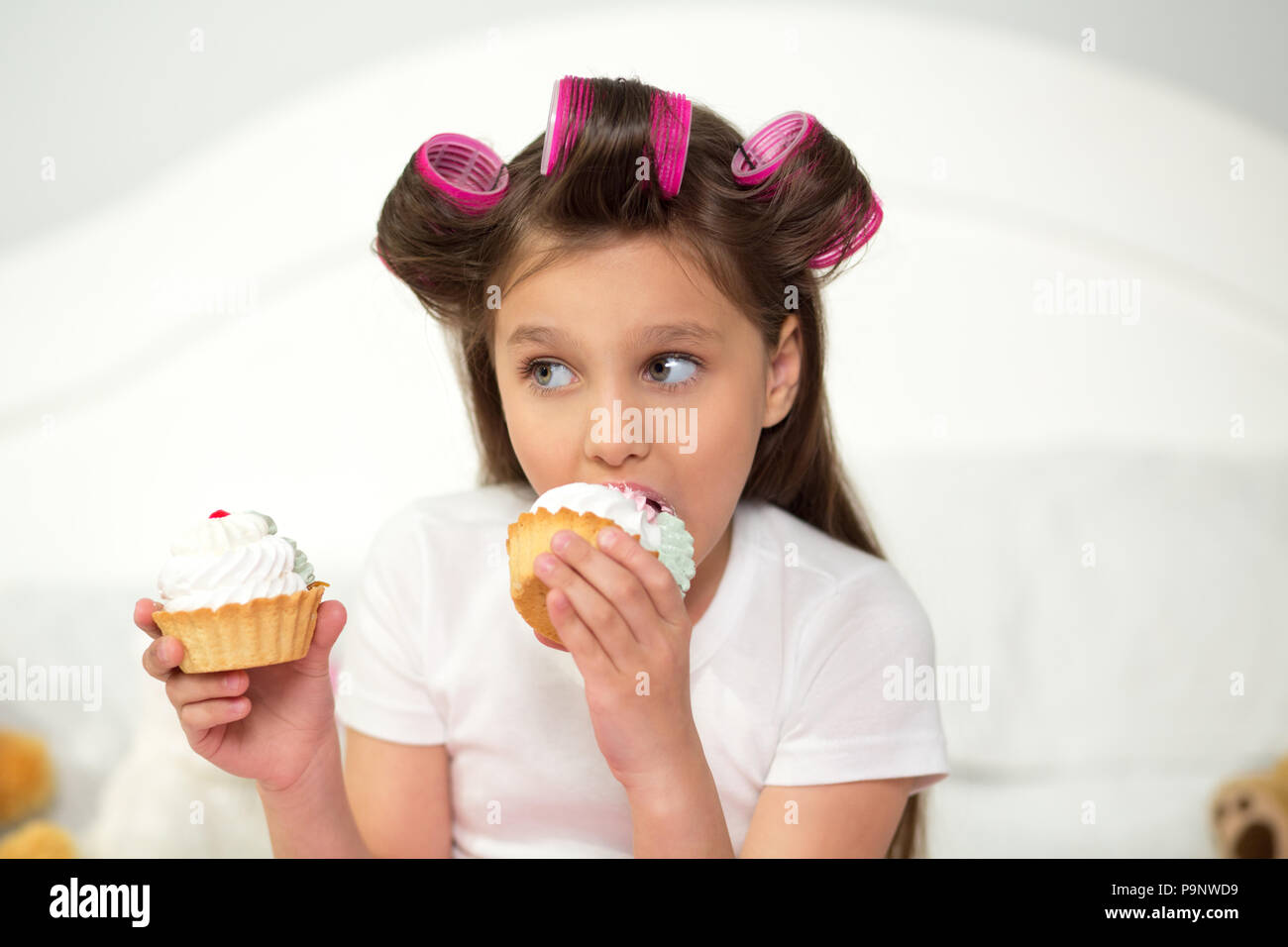 Cute girl eating cupcake Stock Photo - Alamy