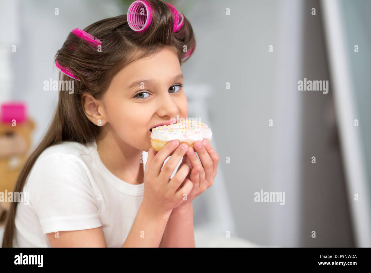 Cute girl eating cupcake Stock Photo - Alamy