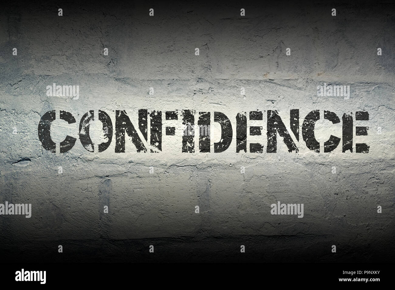confidence stencil print on the grunge white brick wall Stock Photo - Alamy