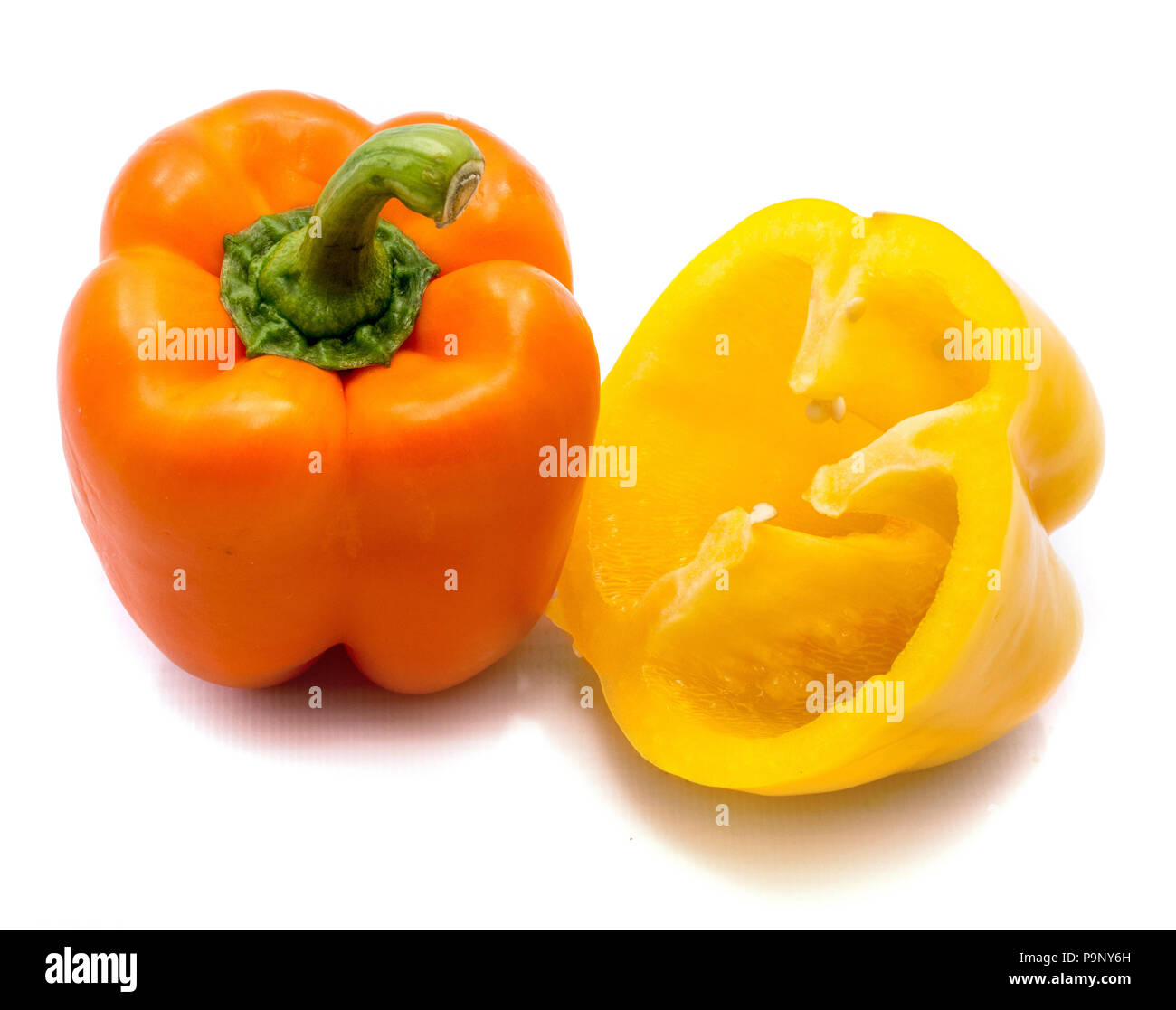 One whole orange pepper and cut yellow pepper isolated on white background Stock Photo - Alamy