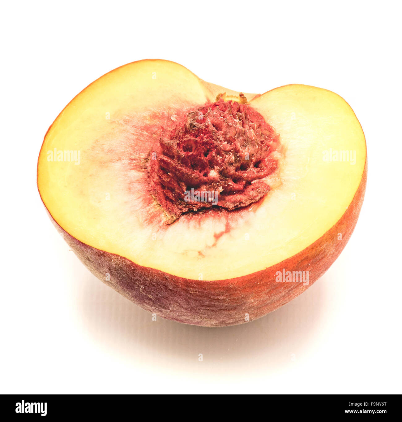One peach half with a corrugated stone isolated on white background ...