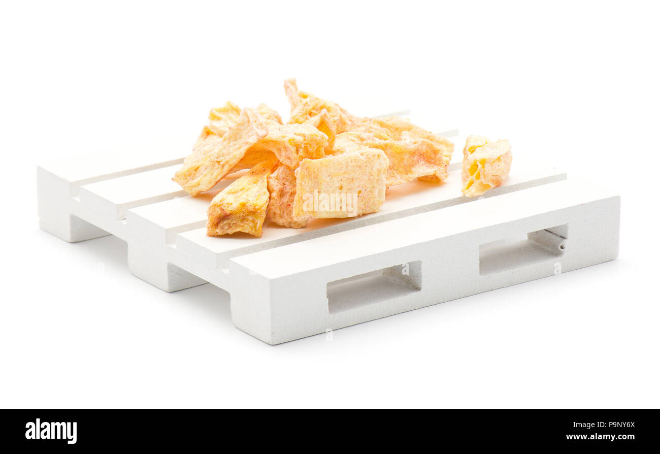 Freeze dried pineapple slices on a pallet isolated on white background ...