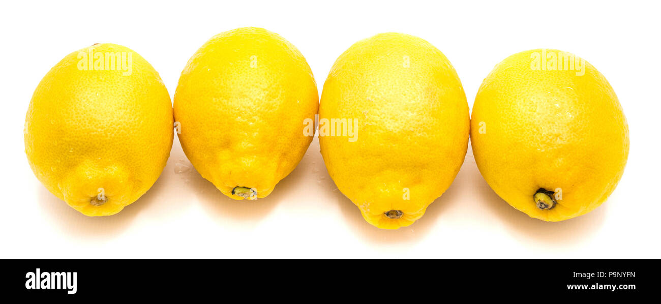 Group of four whole yellow lemons in row isolated on white background ...