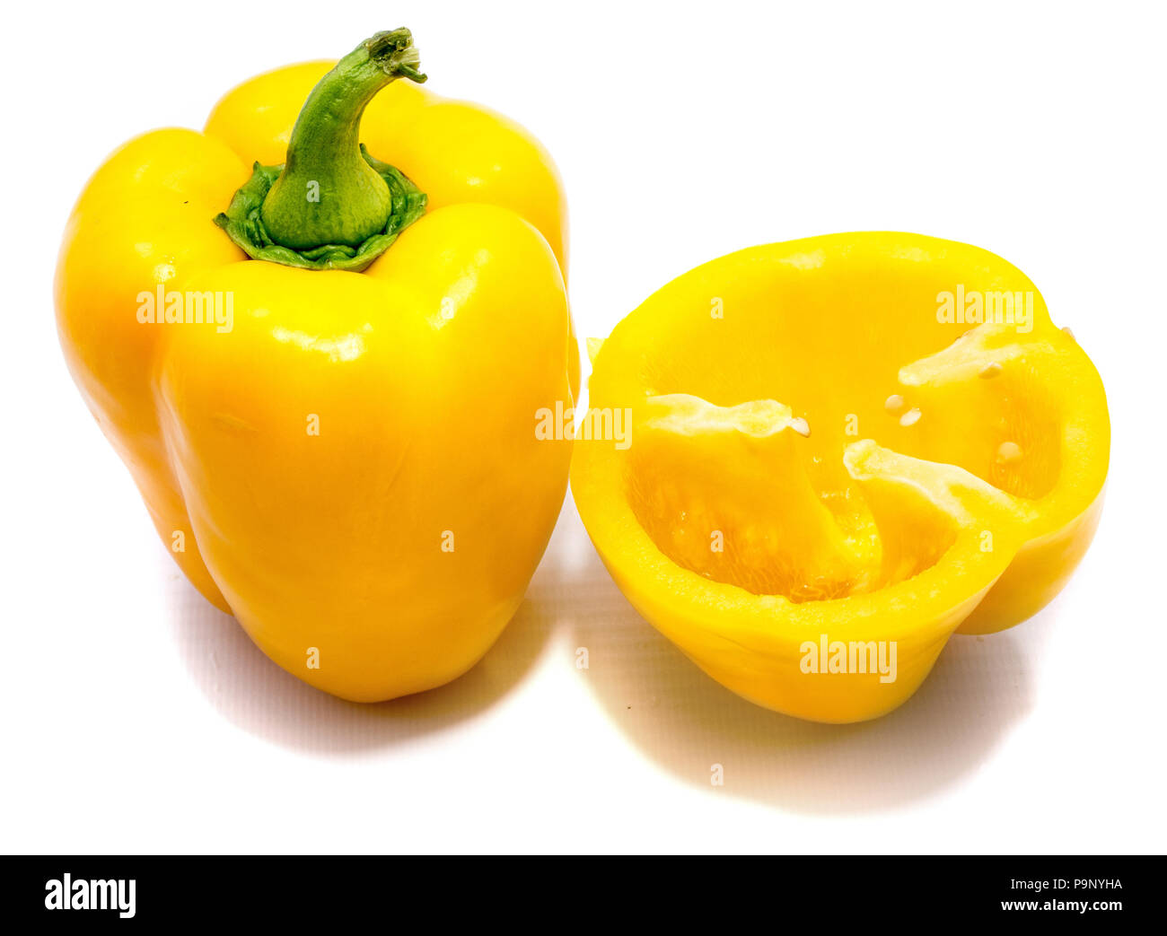 One whole yellow pepper and cut yellow pepper with seeds isolated on ...