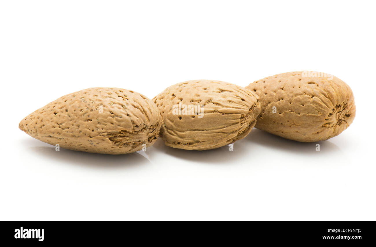 Three unshelled almonds in row isolated on white background Stock Photo ...