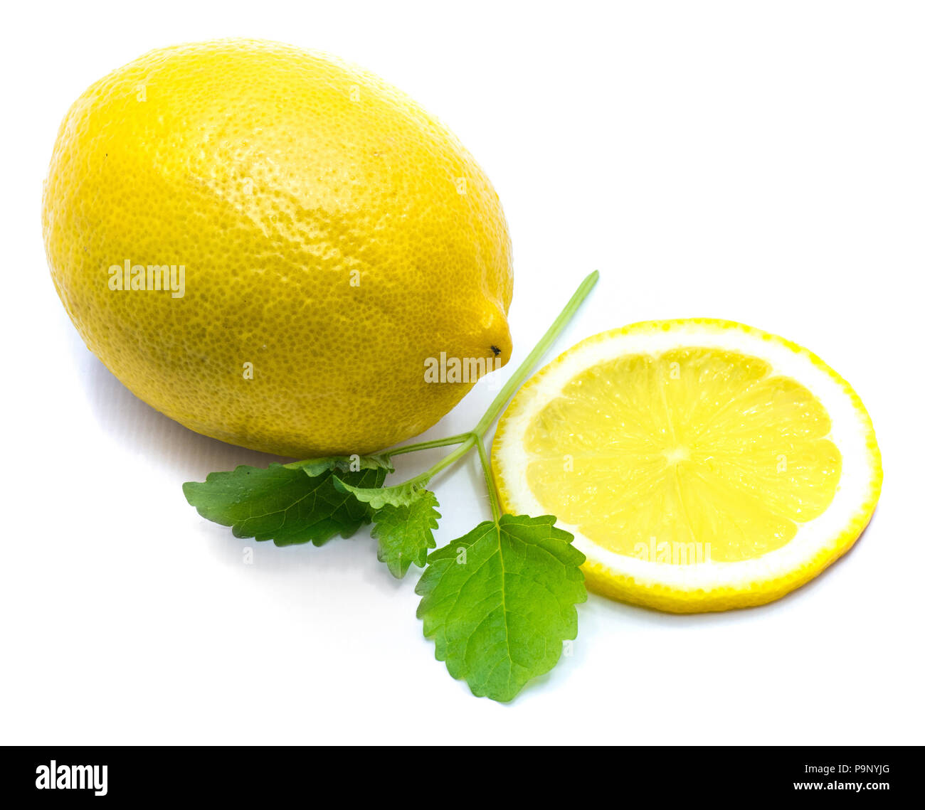 One whole yellow slice and fresh green lemon balm leaves isolated on ...