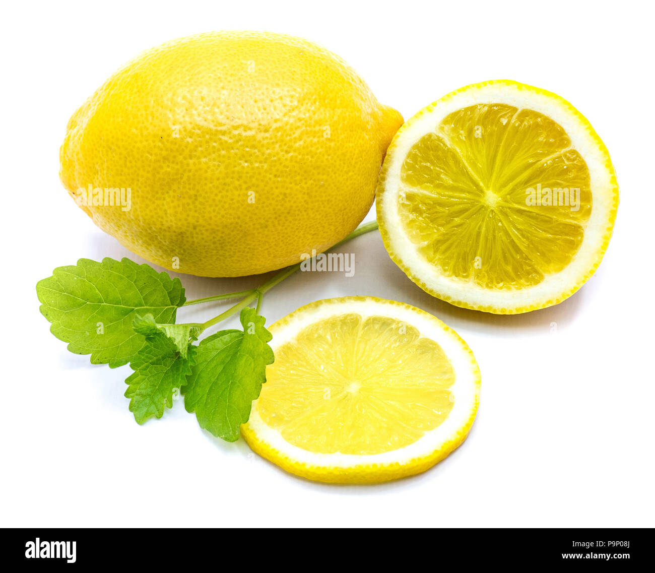 One whole yellow lemon with a half and slice and fresh green lemon balm ...
