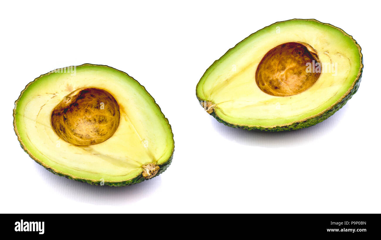 Two avocado halves (Persea americana, alligator pear) isolated on white ...