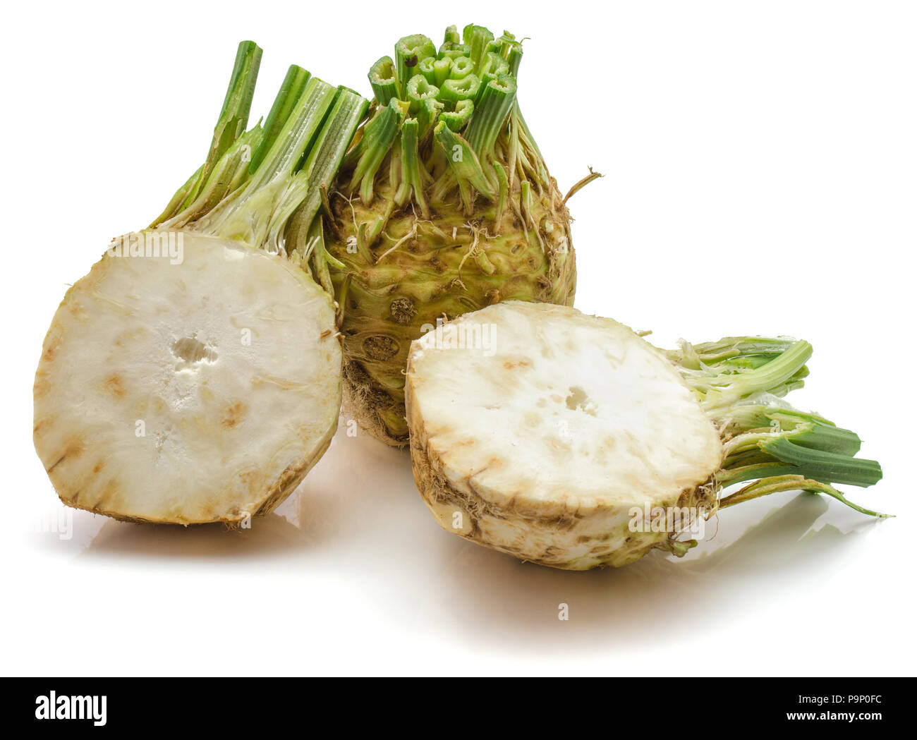 One whole and two halves of fresh celery root isolated on white ...