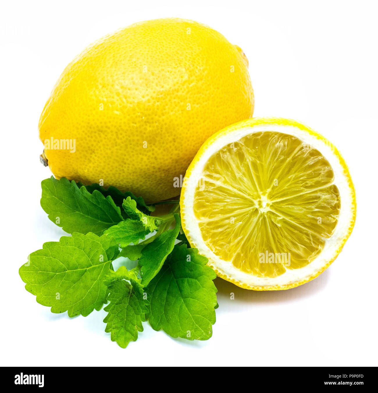 One whole yellow cross section half and fresh green lemon balm leaves ...