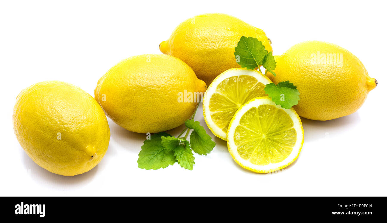 Group of whole yellow lemons, half and slice with fresh lemon balm ...