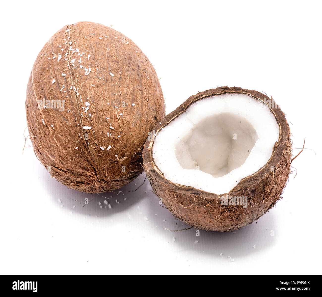 One whole coconut with shavings and one half isolated on white ...