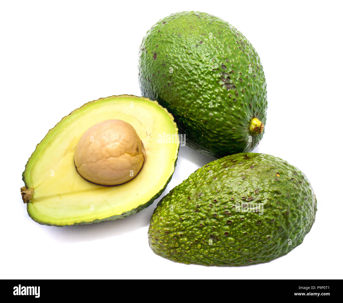Whole and avocado halves (Persea americana, alligator pear) with a ...