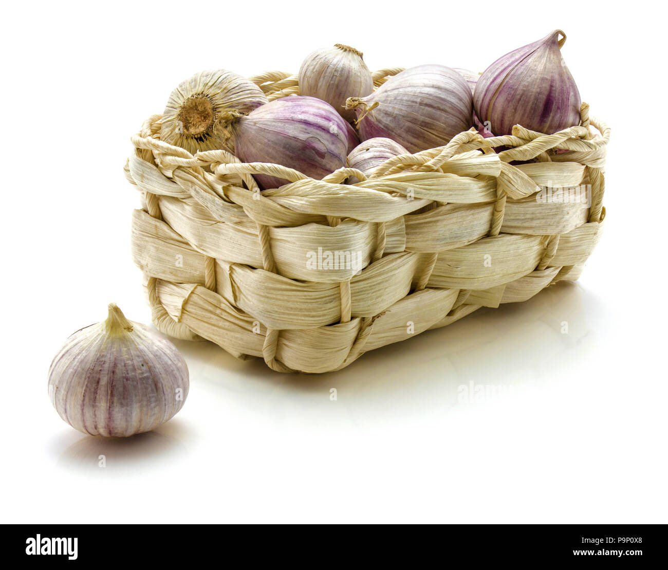 Solo garlic in straw basket isolated on white background single clove ...