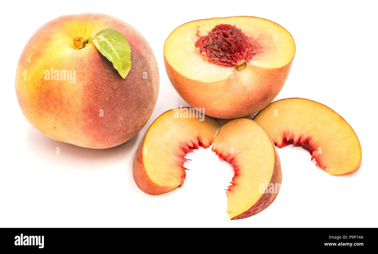 Group of peaches, whole with a green leaf, one half with a stone ...