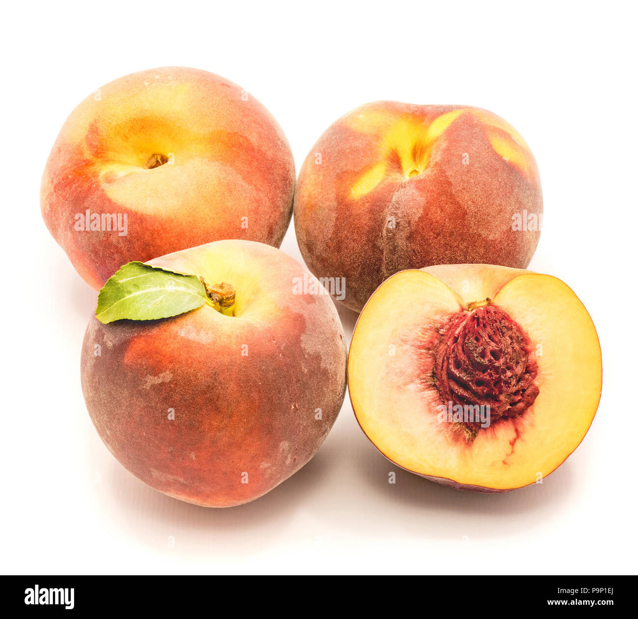 Three peaches and one sliced half with a stone isolated on white ...