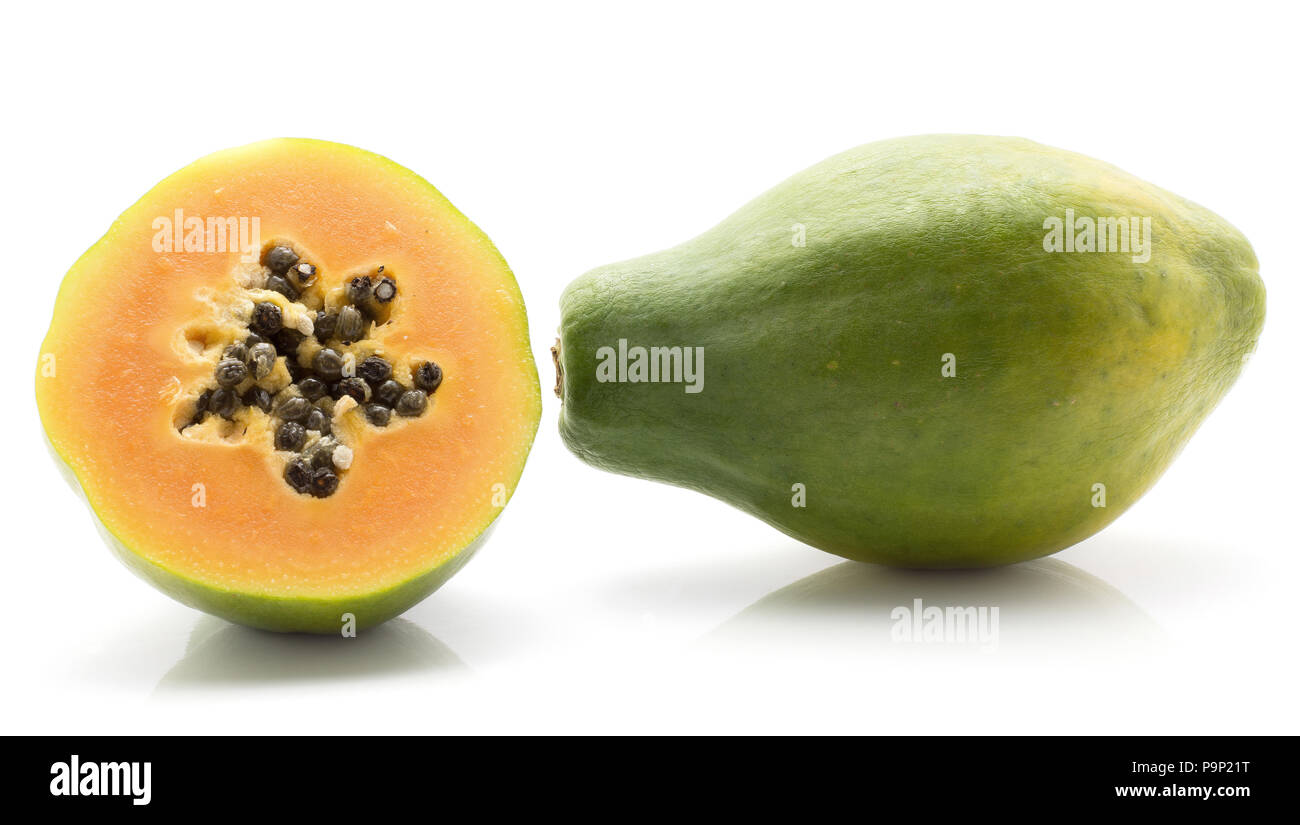 Green papaya (pawpaw, papaw) one whole one sliced half with seeds ...