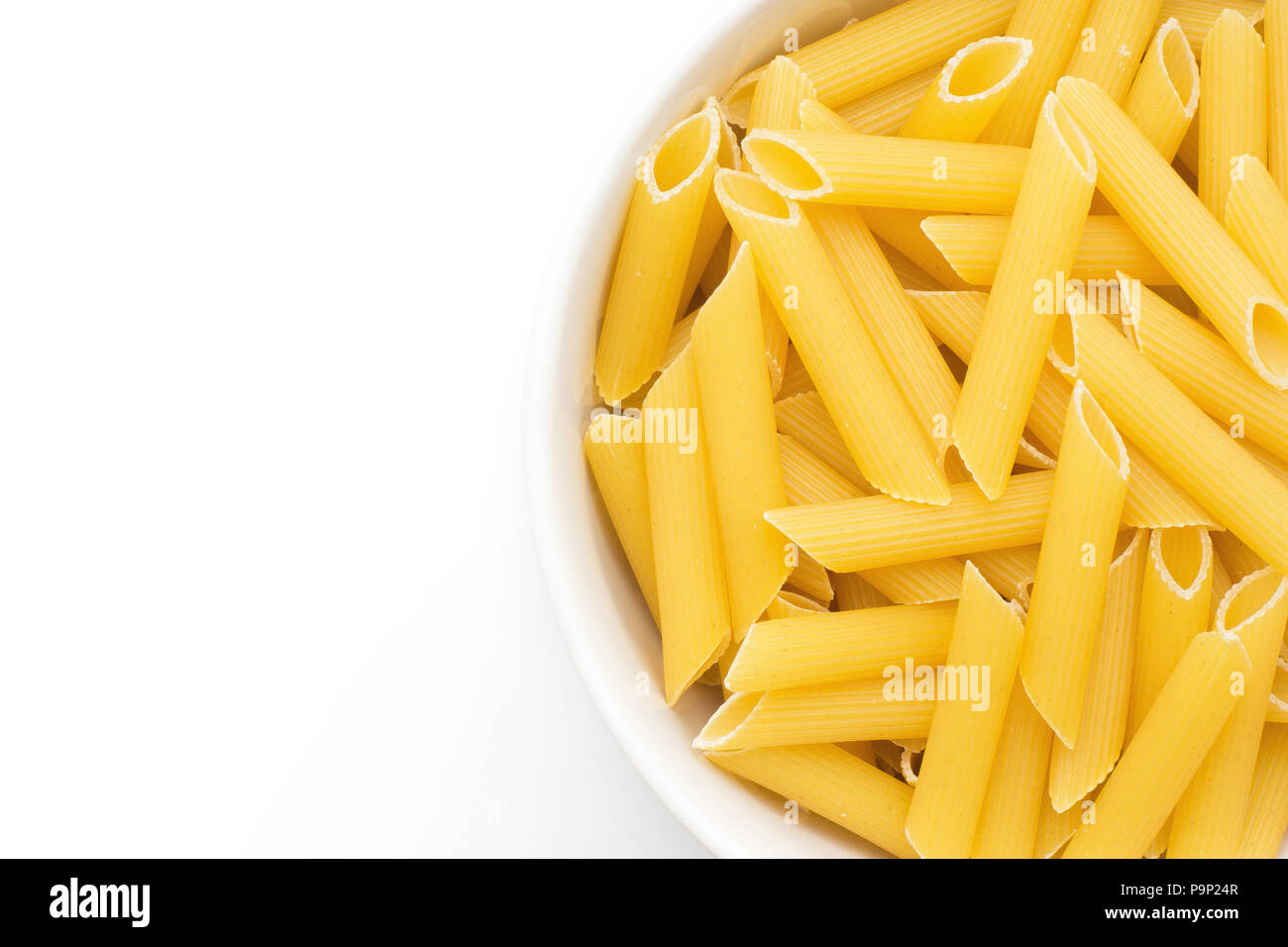 Penne rigate in porcelain bowl top view raw isolated on white ...