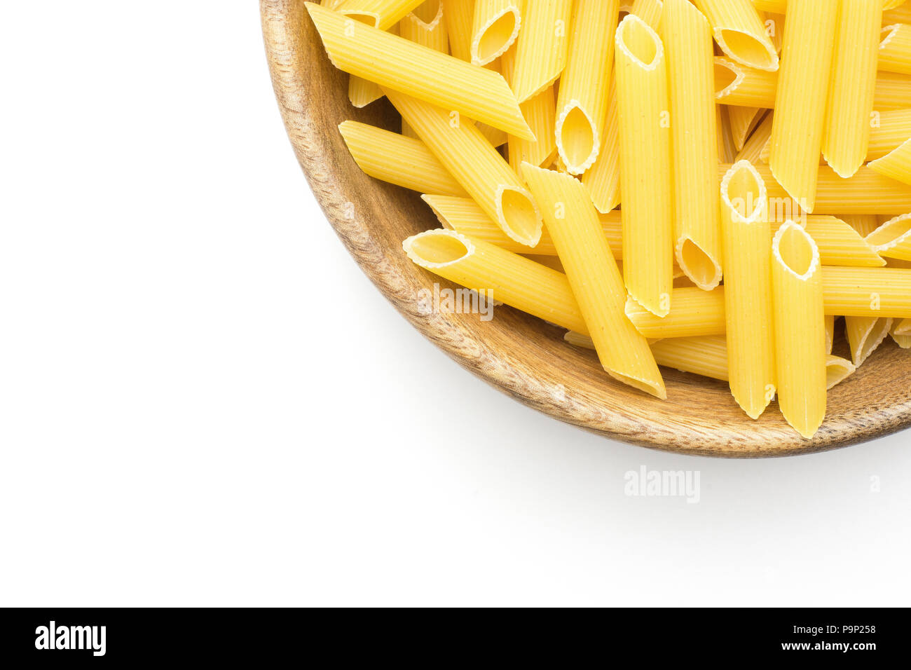 Penne rigate in wood bowl top view raw isolated on white background ...