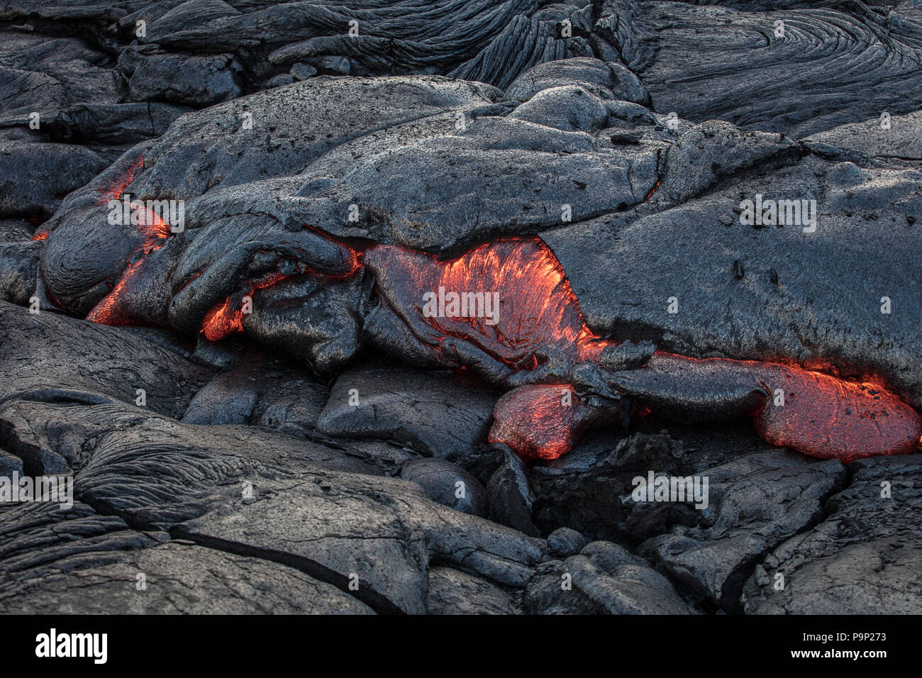 Red lava flow from black volcanic ground on melted dark background ...