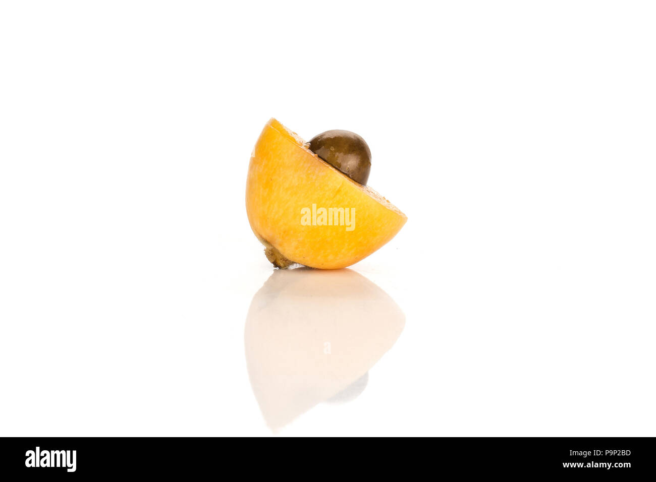 One fresh orange Japanese loquat half with a seed inside isolated on ...