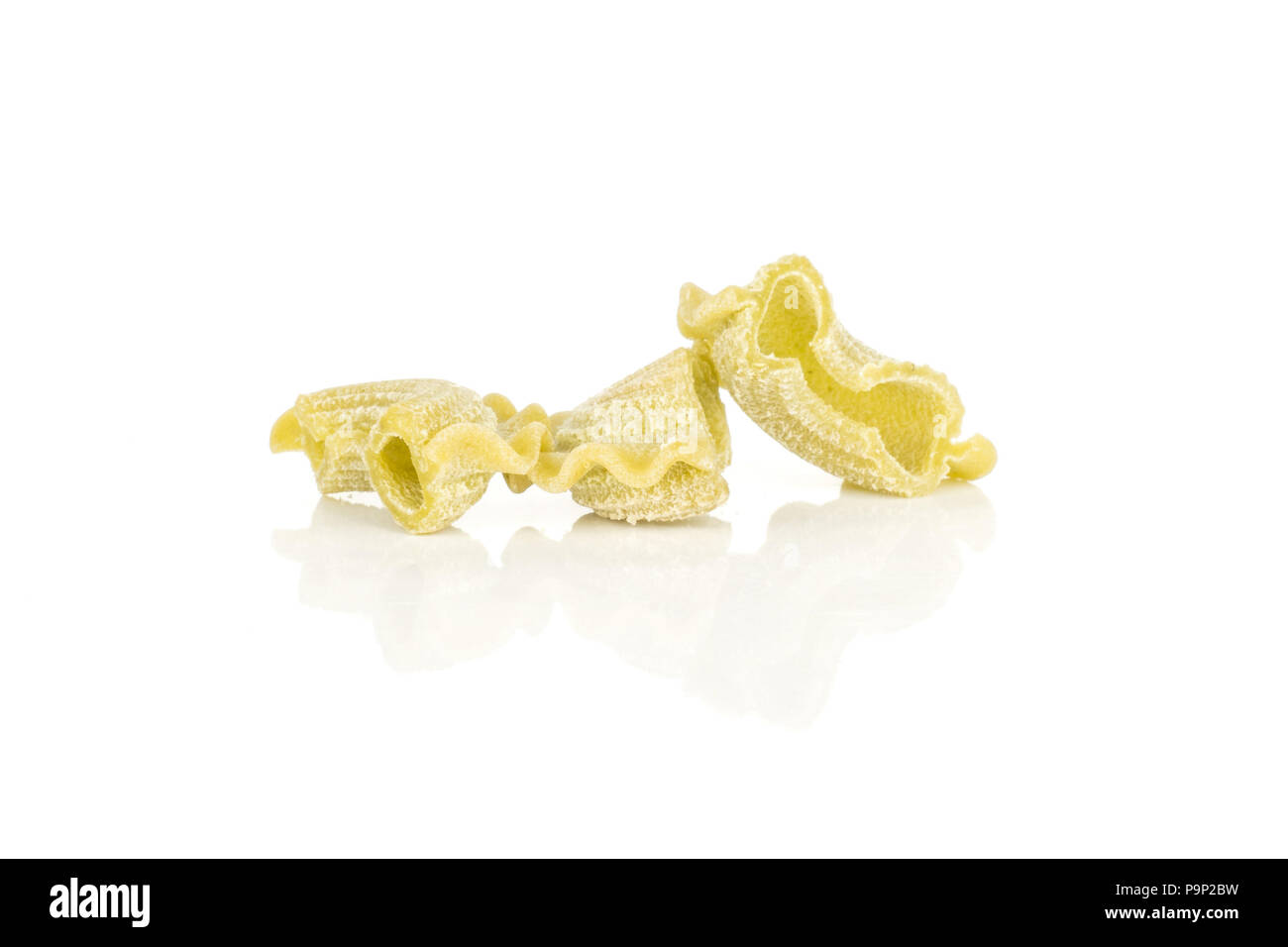 Three pasta creste di gallo spinach raw isolated on white background ...