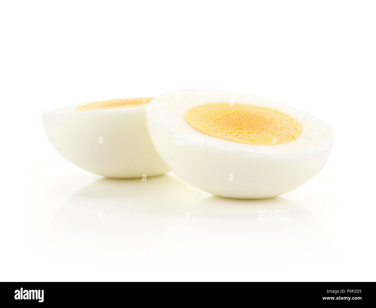 Two boiled chicken egg halves isolated on white background one cut in ...