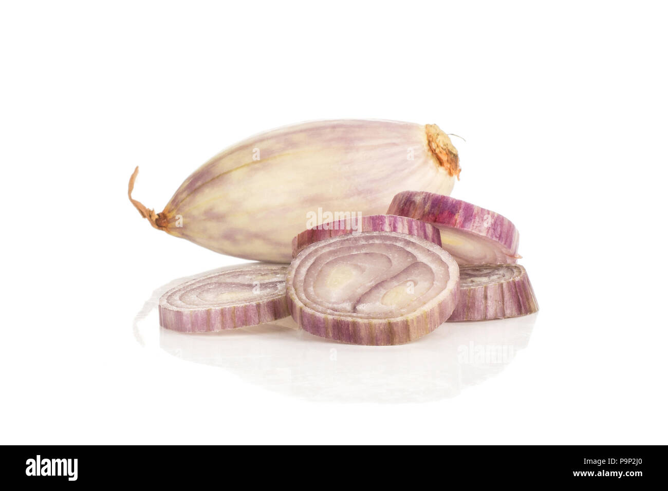One peeled shallot and ring slices stack isolated on white background ...