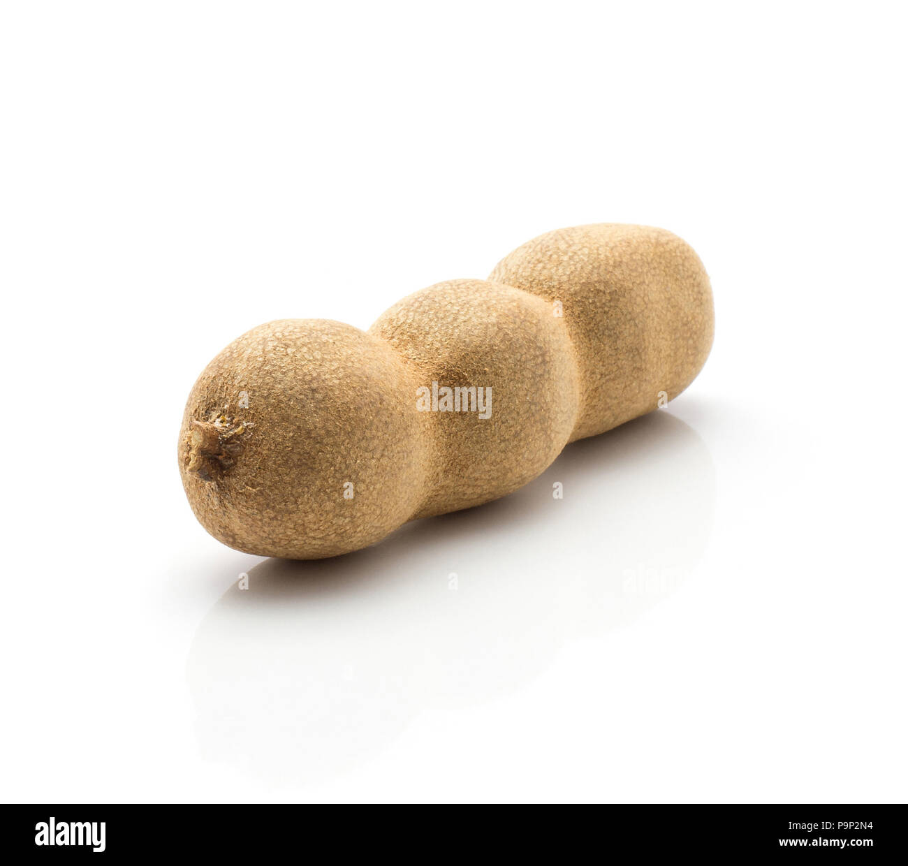 One tamarind Indian date in a brown brittle shell isolated on white ...