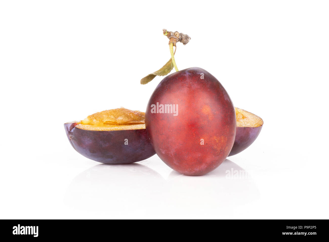 Group of one whole two halves of fresh violet-blue plum vibrant moyer ...