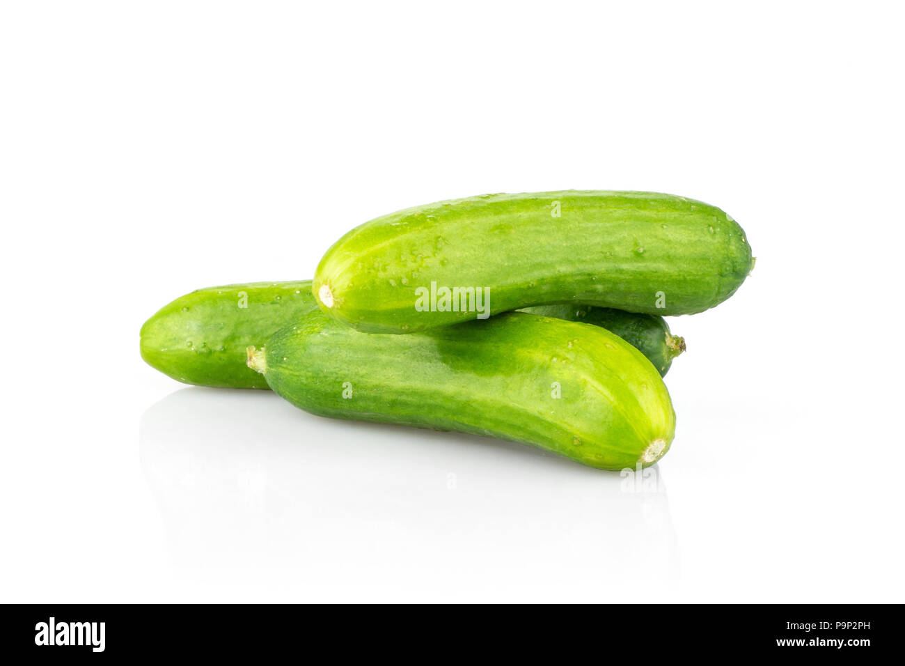 Three fresh green mini cucumbers stack isolated on white background ...
