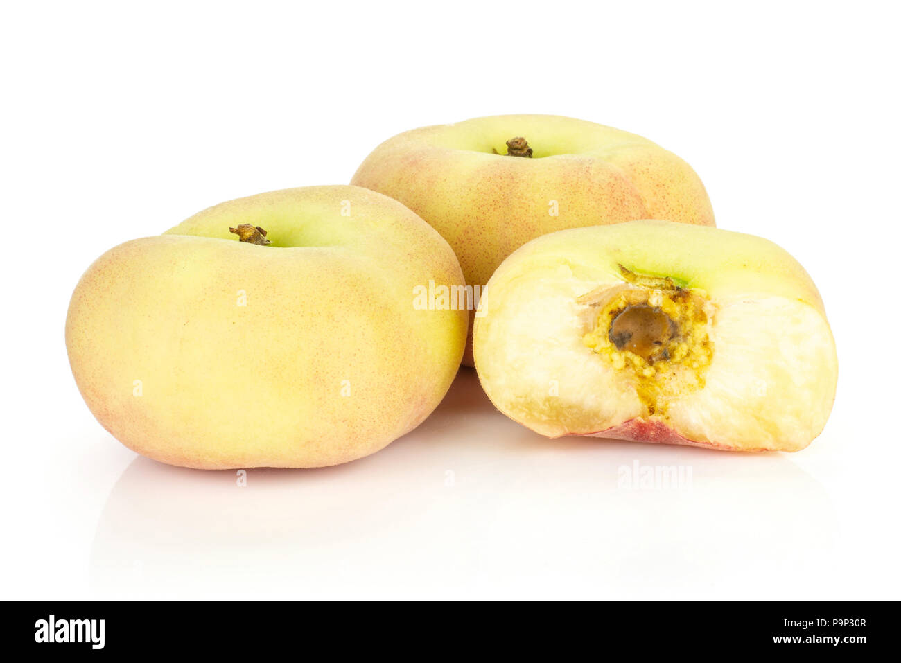 Two fresh ripe Saturn peaches with one half isolated on white ...
