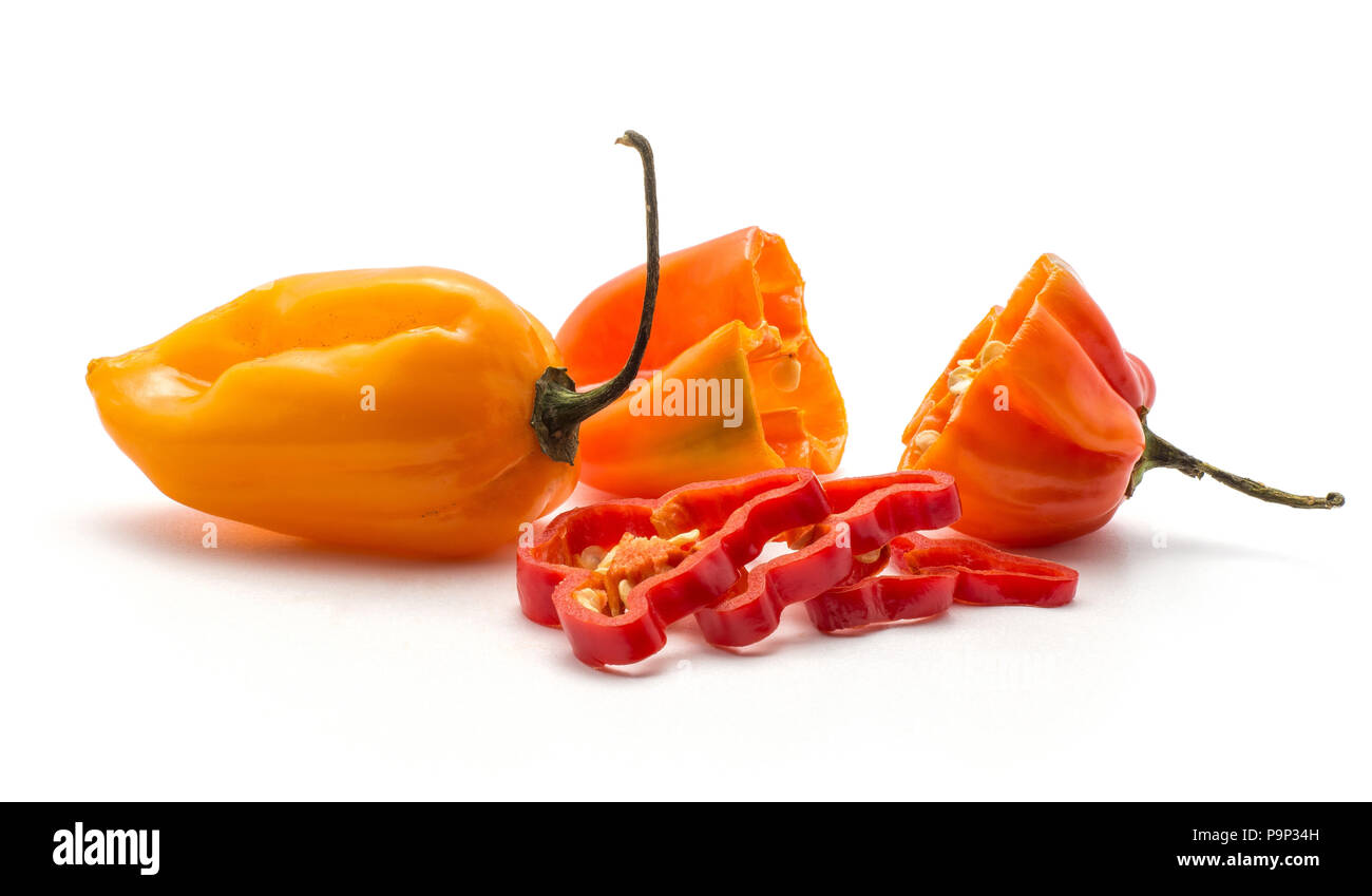 Two orange Habanero chili with red chopped slices isolated on white ...