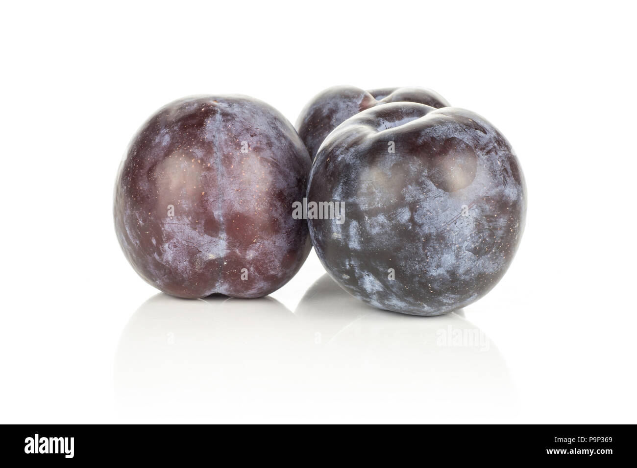 Three red blue plums isolated on white background round fresh juicy ...