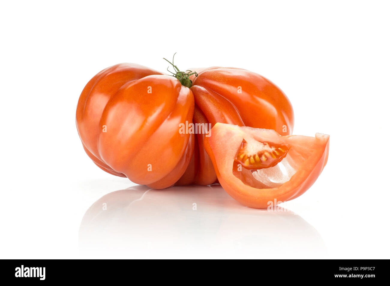 One beef tomato with a slice isolated on white background big ripe red ...