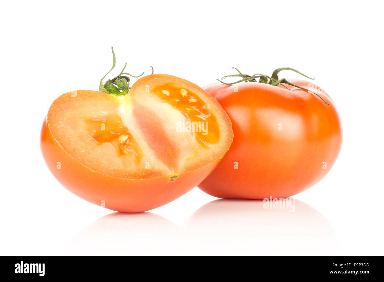 One red tomato and one sliced section half isolated on white background ...