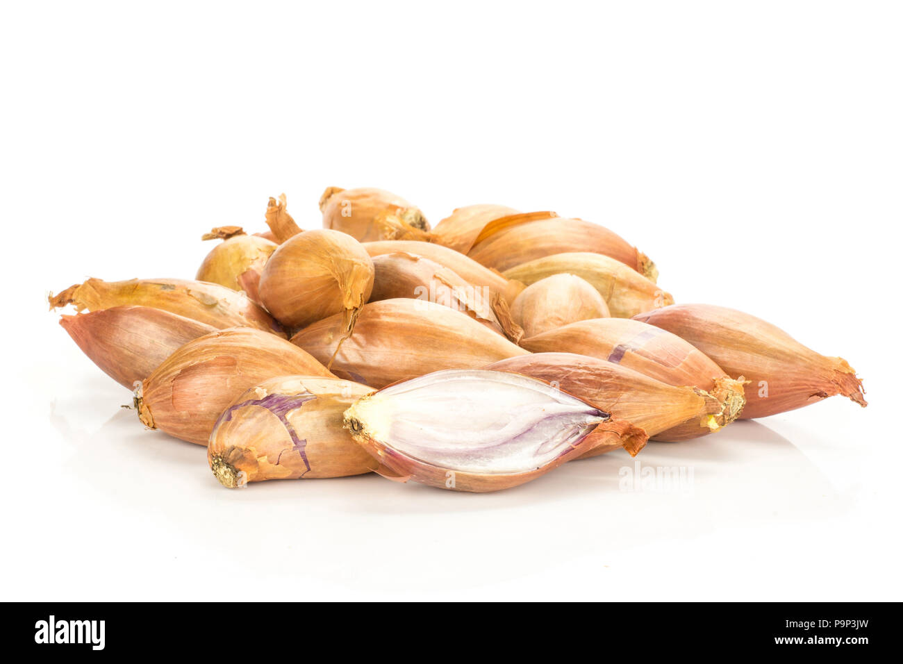 Golden shallots stack and one sliced half isolated on white background ...