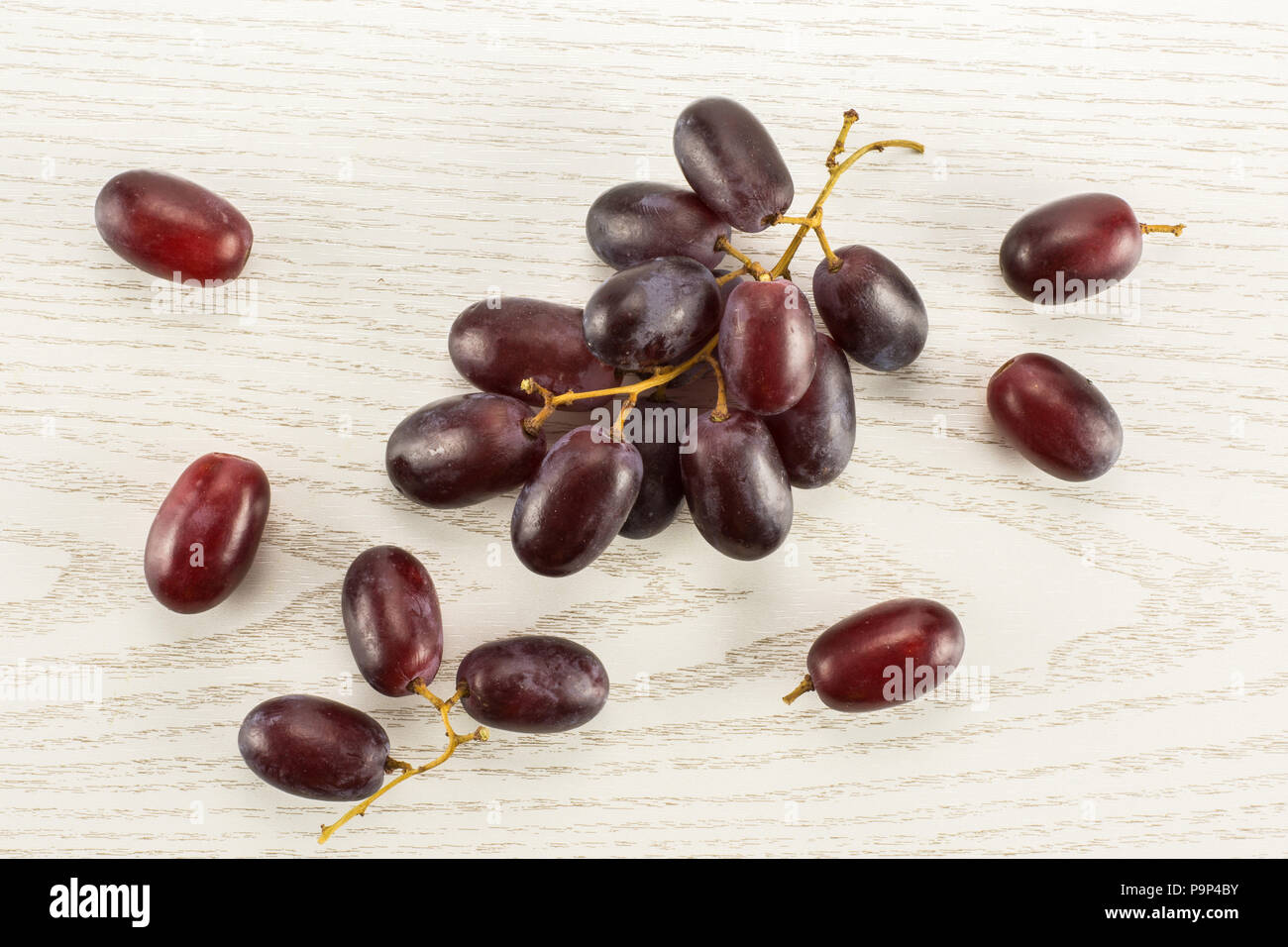Red globe grape table top isolated on grey wood background dark pink ...