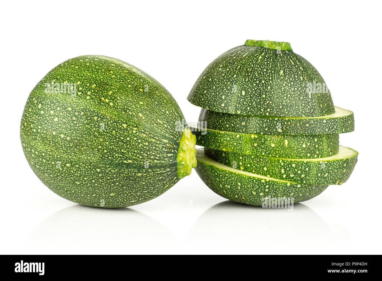 One whole and sliced round zucchini isolated on white background fresh ...