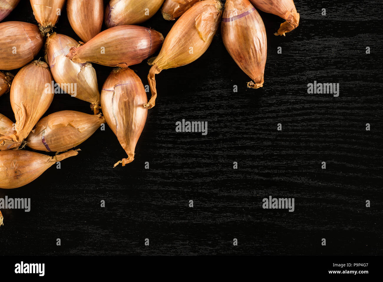 Long golden shallots flatlay isolated on black wood background Stock ...