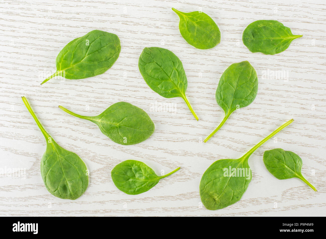 Fresh baby spinach leaves top view on grey wood background Stock Photo ...